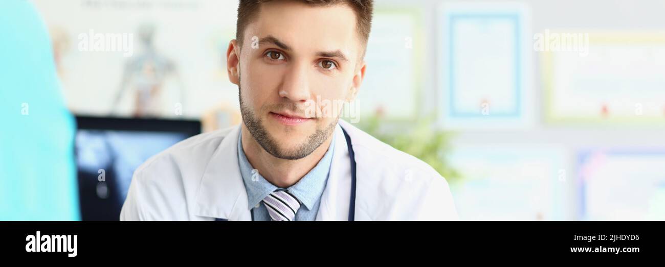 Attractive young medical worker in white uniform, wait patient for ...