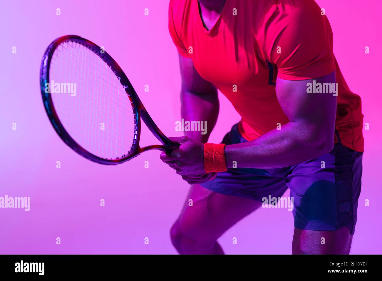 Image of midsection of african american male tennis player in neon ...
