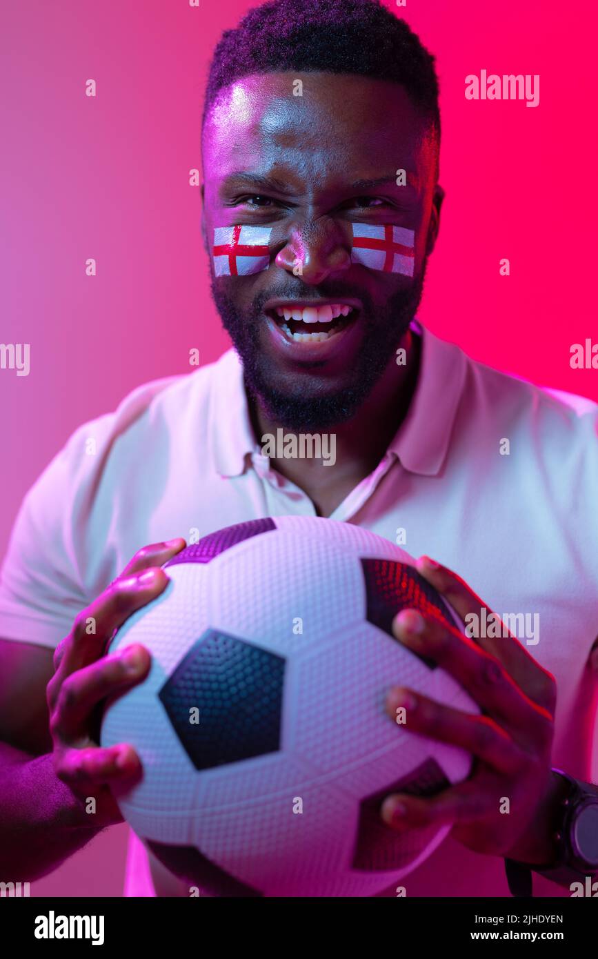 Vertical image of african american male soccer fan with flag of england ...