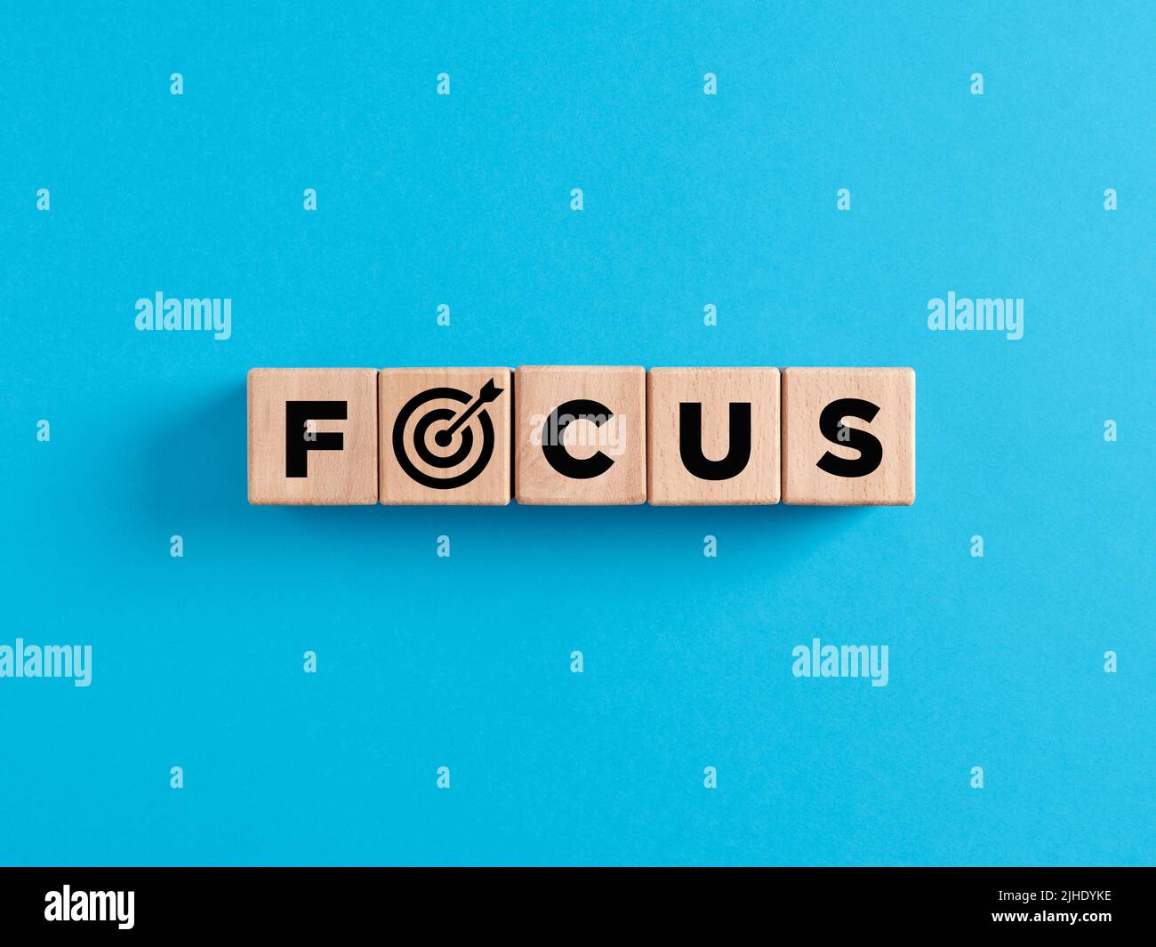 The word focus on wooden cubes with target icon. Focusing or ...