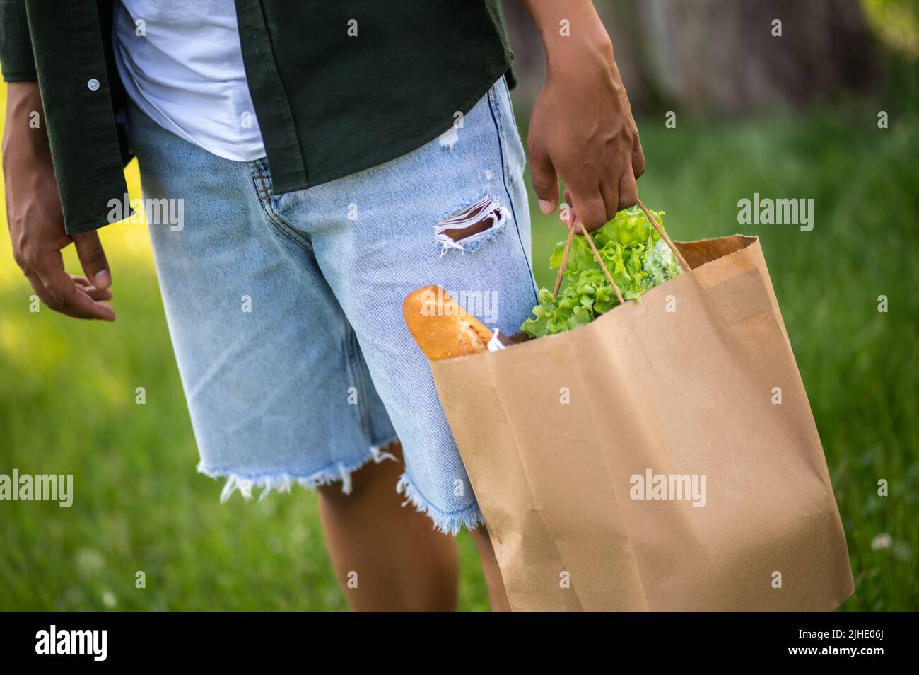 Mans hand holding bag of food Stock Photo - Alamy