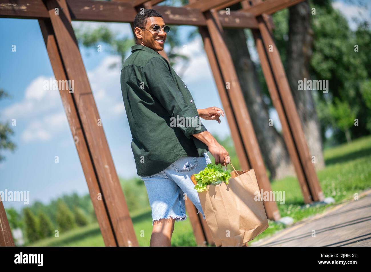 Guy looking back at camera walking in park Stock Photo - Alamy