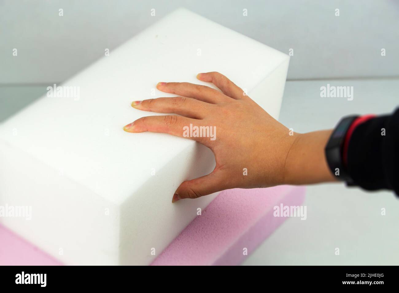 the hand presses on the surface of the rubber foam. Checking hardness ...