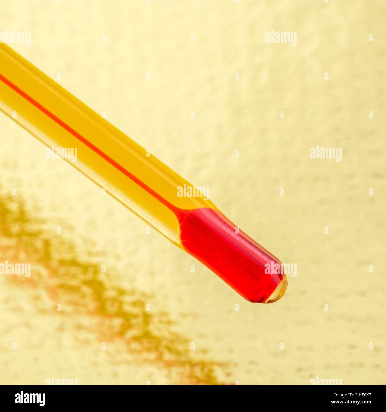 Glass red ink thermometer bulb on a colour background. For 202.32 ...