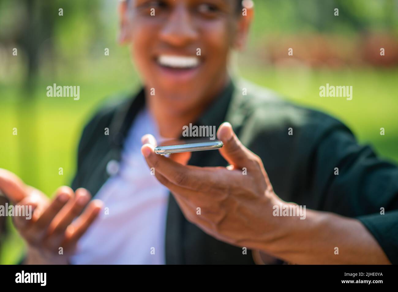 Smartphone in hand of talking man Stock Photo - Alamy