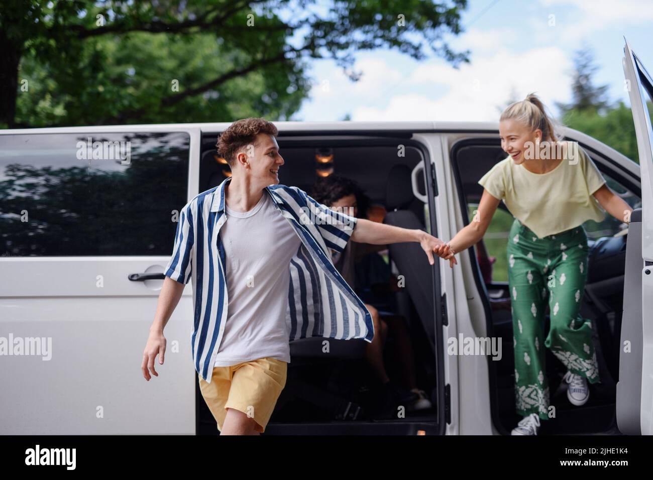 Young friends travelling together by car,getting out from car - summer ...