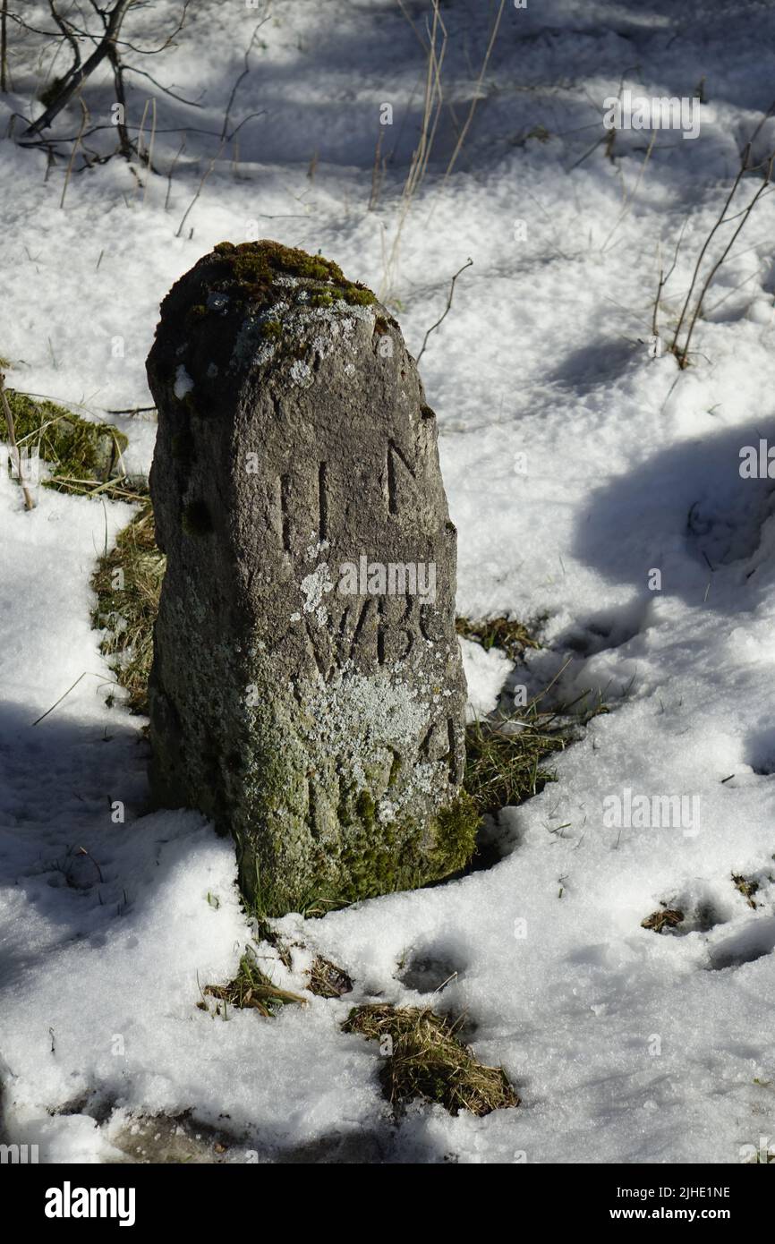 An ancient headstone in a forest covered with snow Stock Photo - Alamy