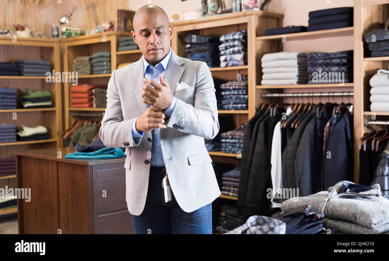Man choosing suit jacket in clothing store Stock Photo - Alamy