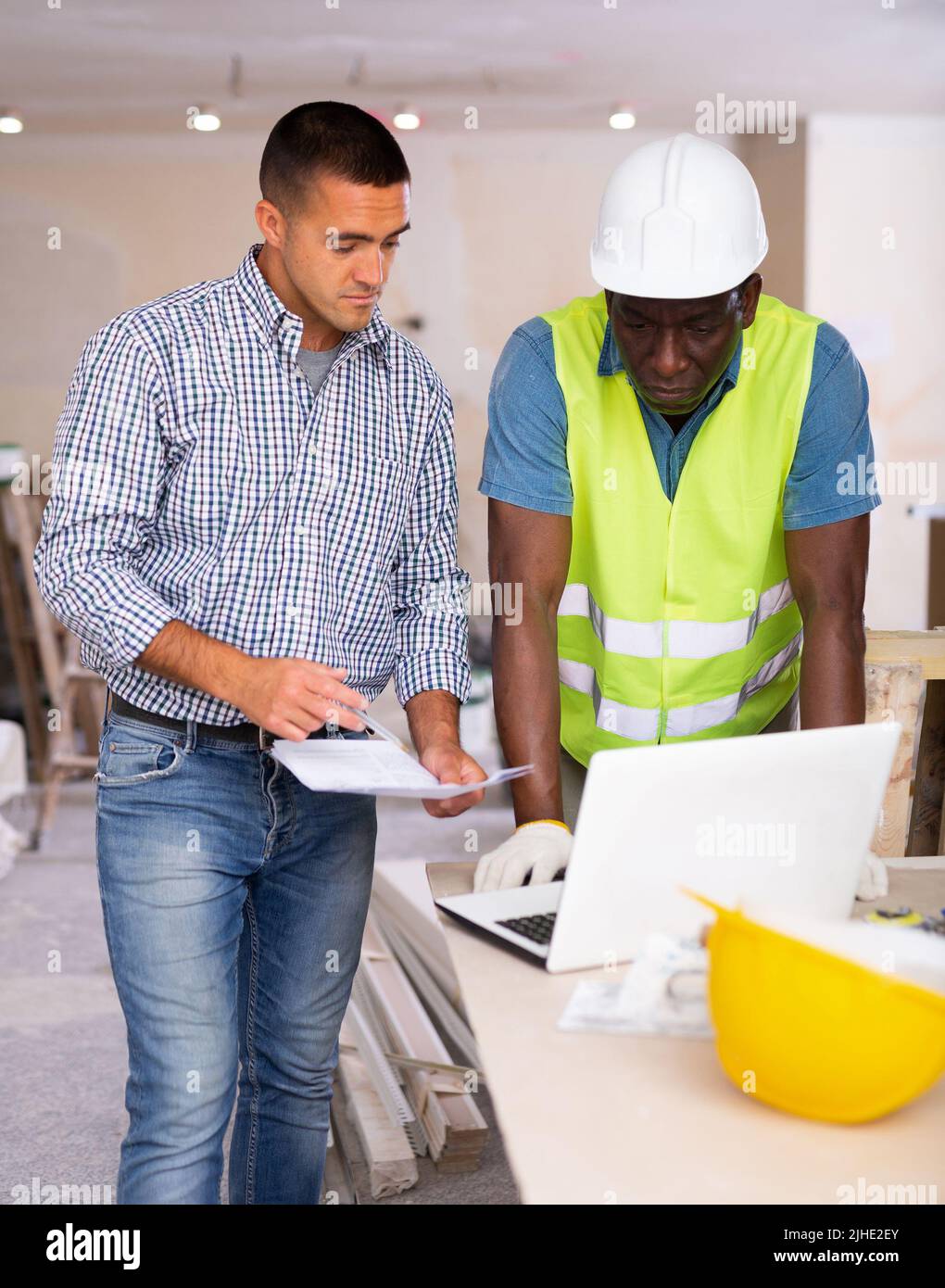 Construction manager and builder talking about repair works in ...