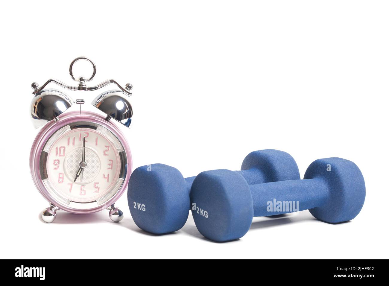 Time for exercising alarm clock and dumbbell isolated on a white ...