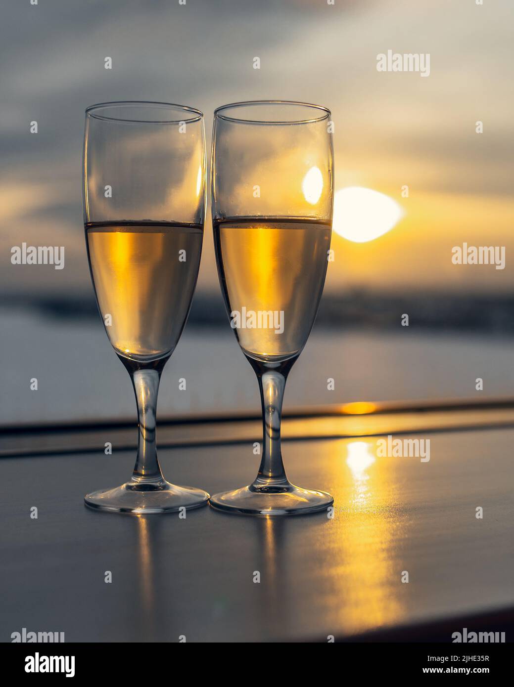 Two glasses with champagne on window on sunset Stock Photo - Alamy