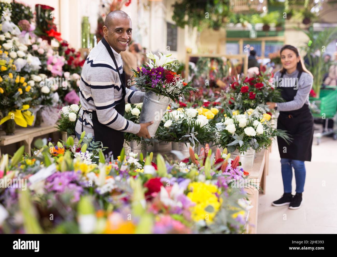 Male flower seller prepares a luxury bouquet at flower shop Stock Photo ...
