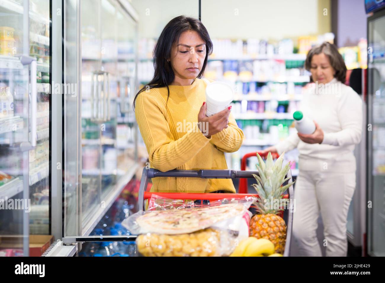 Hispanic woman shopping for milk products in supermarket Stock Photo ...