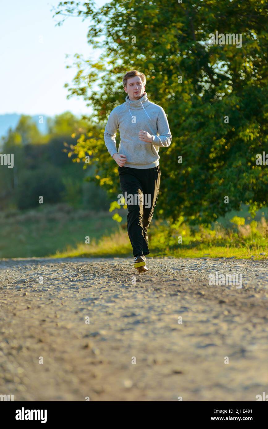 Running man jogging in rural nature at beautiful summer day. Sport ...