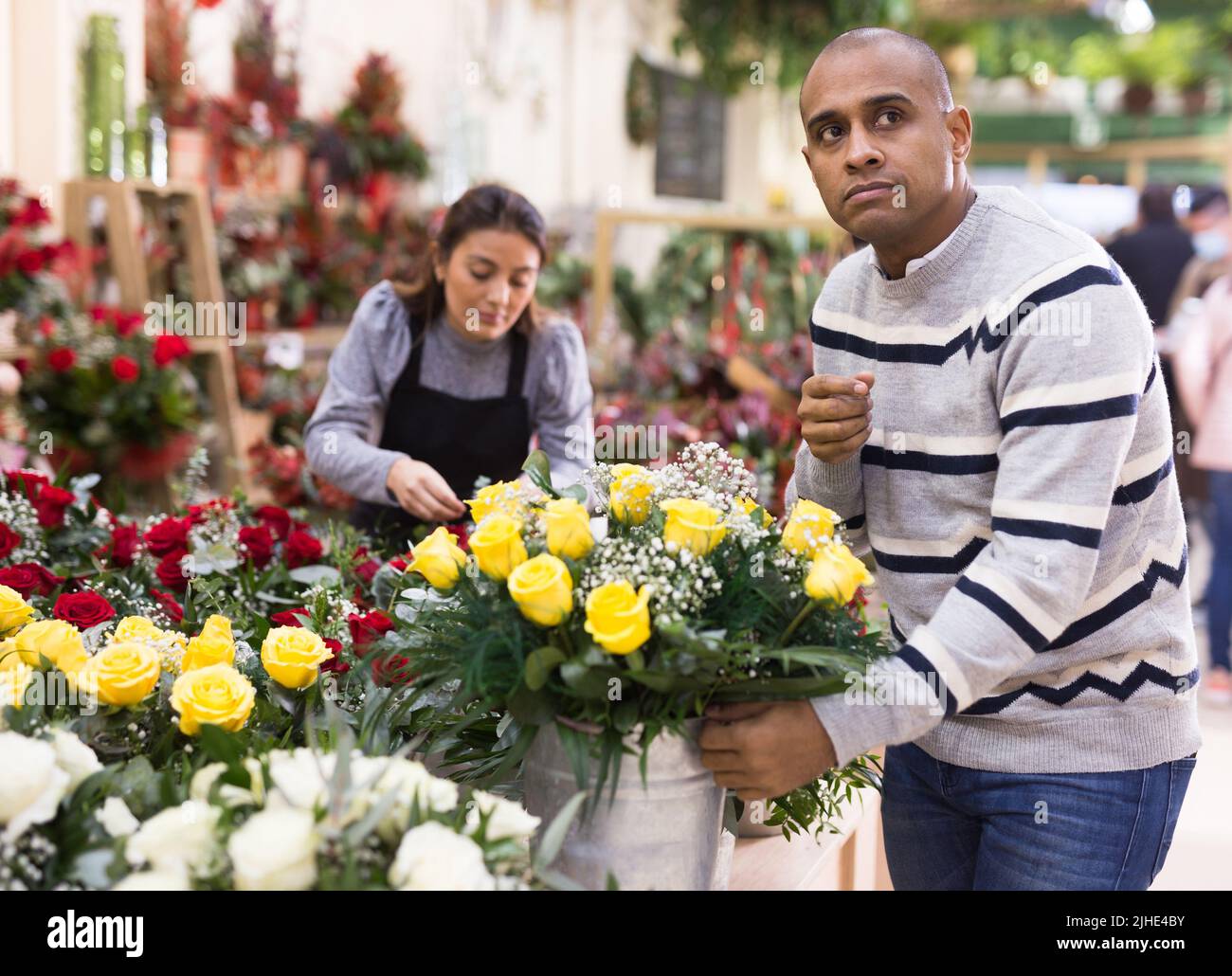 Male customer chooses flowers in shop Stock Photo - Alamy