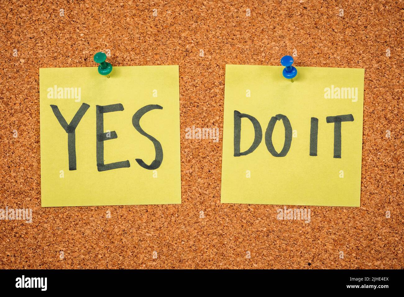 Yellow sticky notes on a cork board with drawing pin with the words Yes ...
