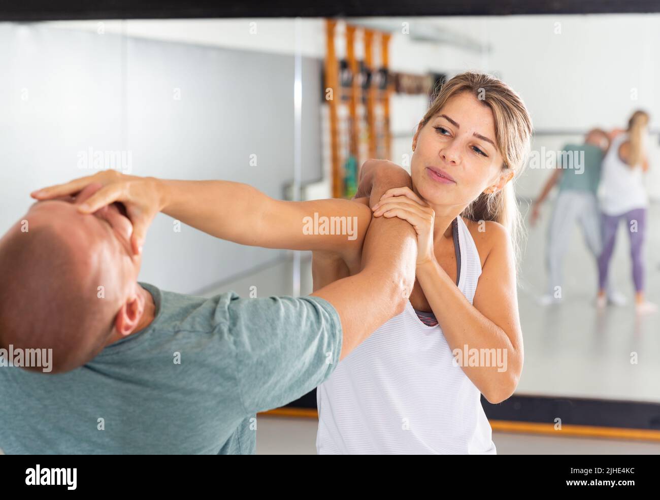 Strong cheerful woman is training with man on the self-defense course ...