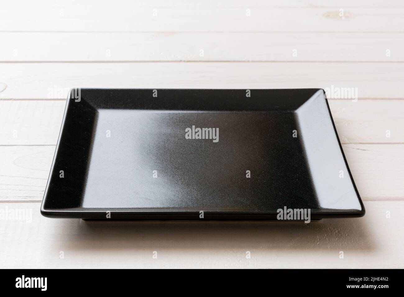 Perspective view of empty square plate on wooden background. Empty ...