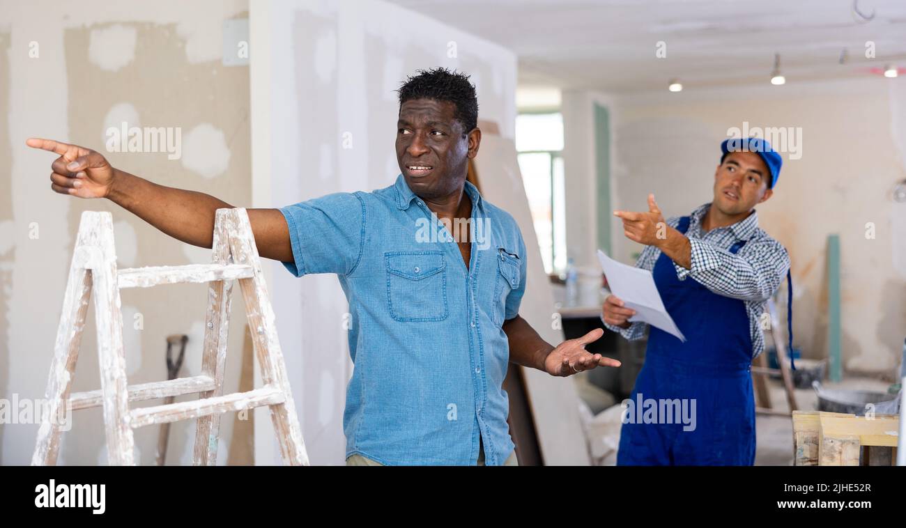 Disappointed owner of apartment showing problem to repairman Stock ...