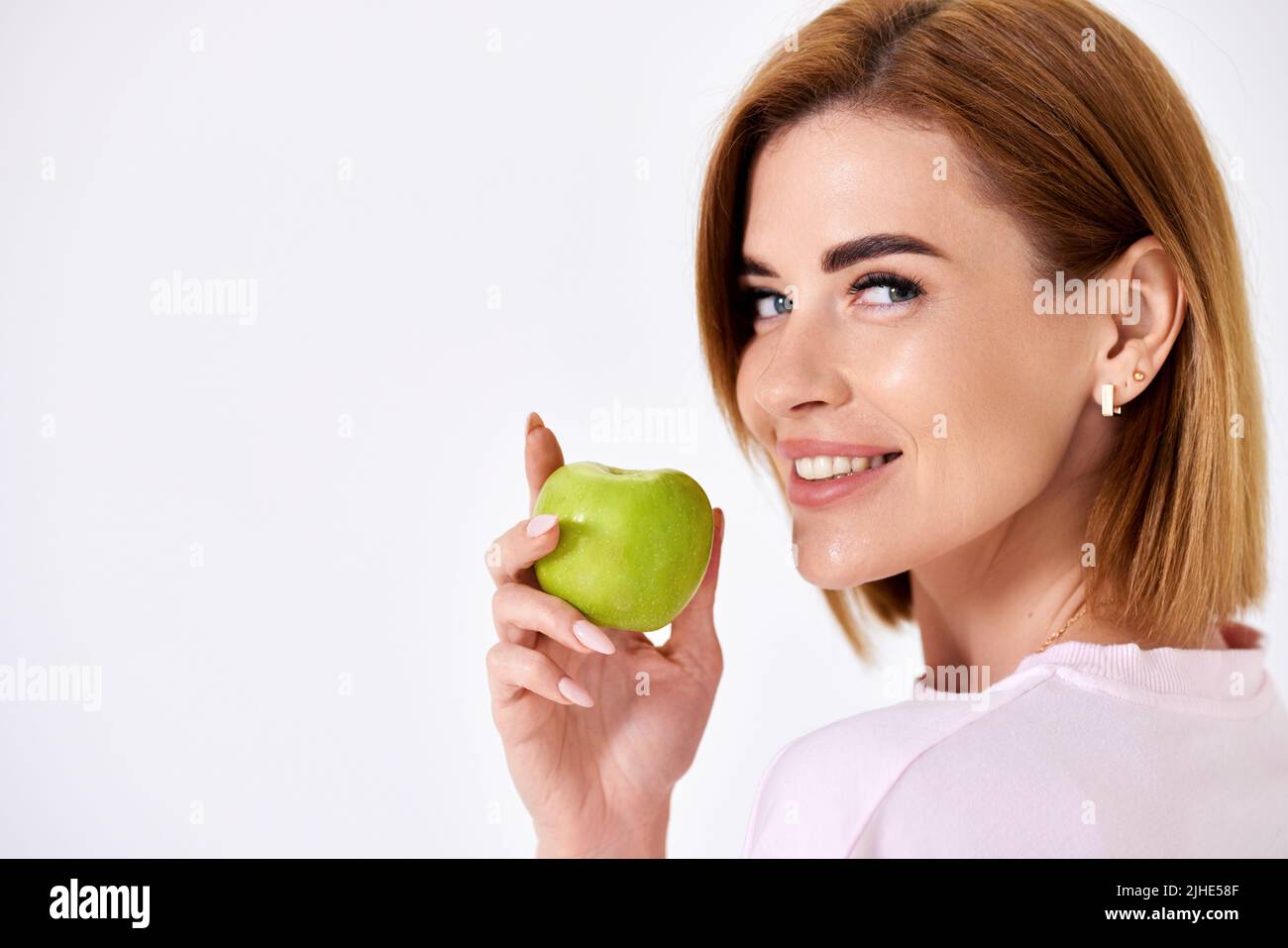 girl holding green apple isolated on white background Stock Photo - Alamy