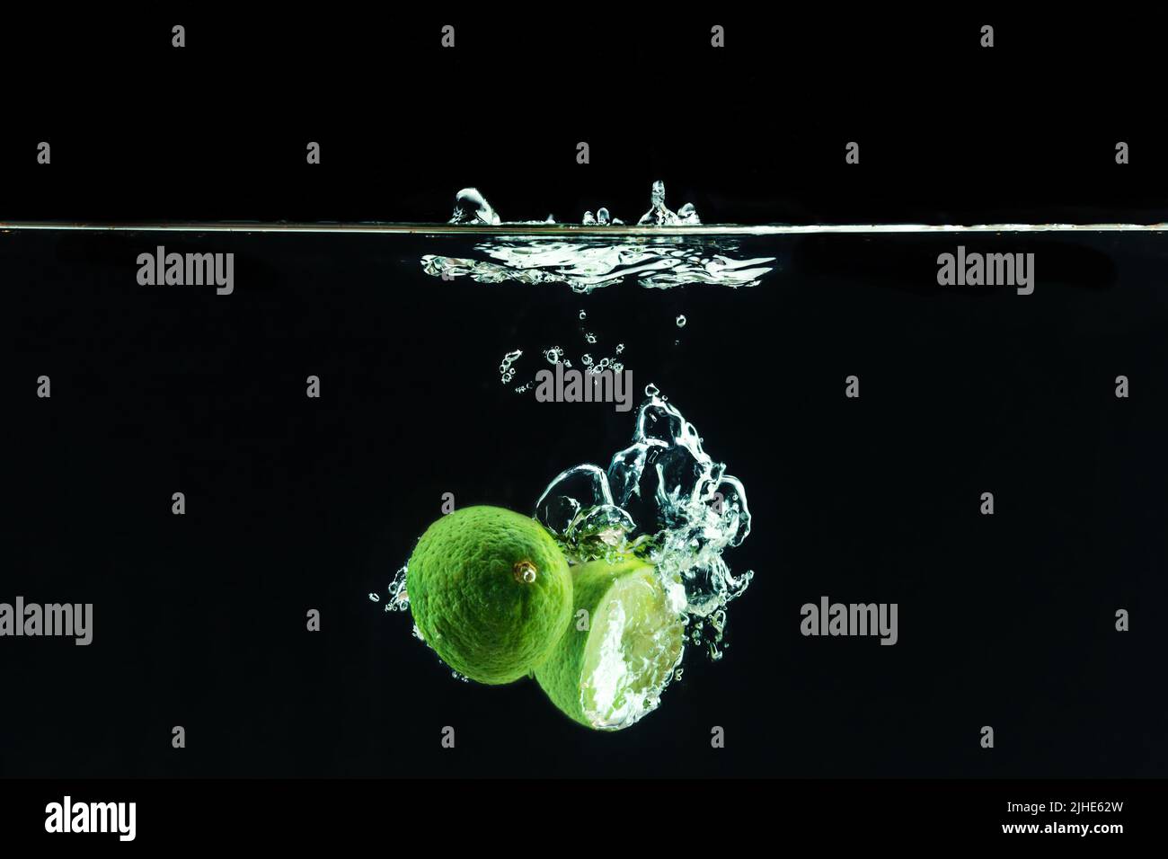Fresh lime dropped into water with splash Stock Photo - Alamy