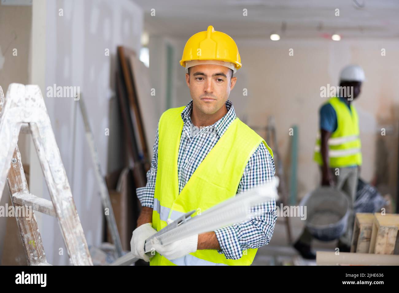 Man builder carrying metallic profile while working in construction ...