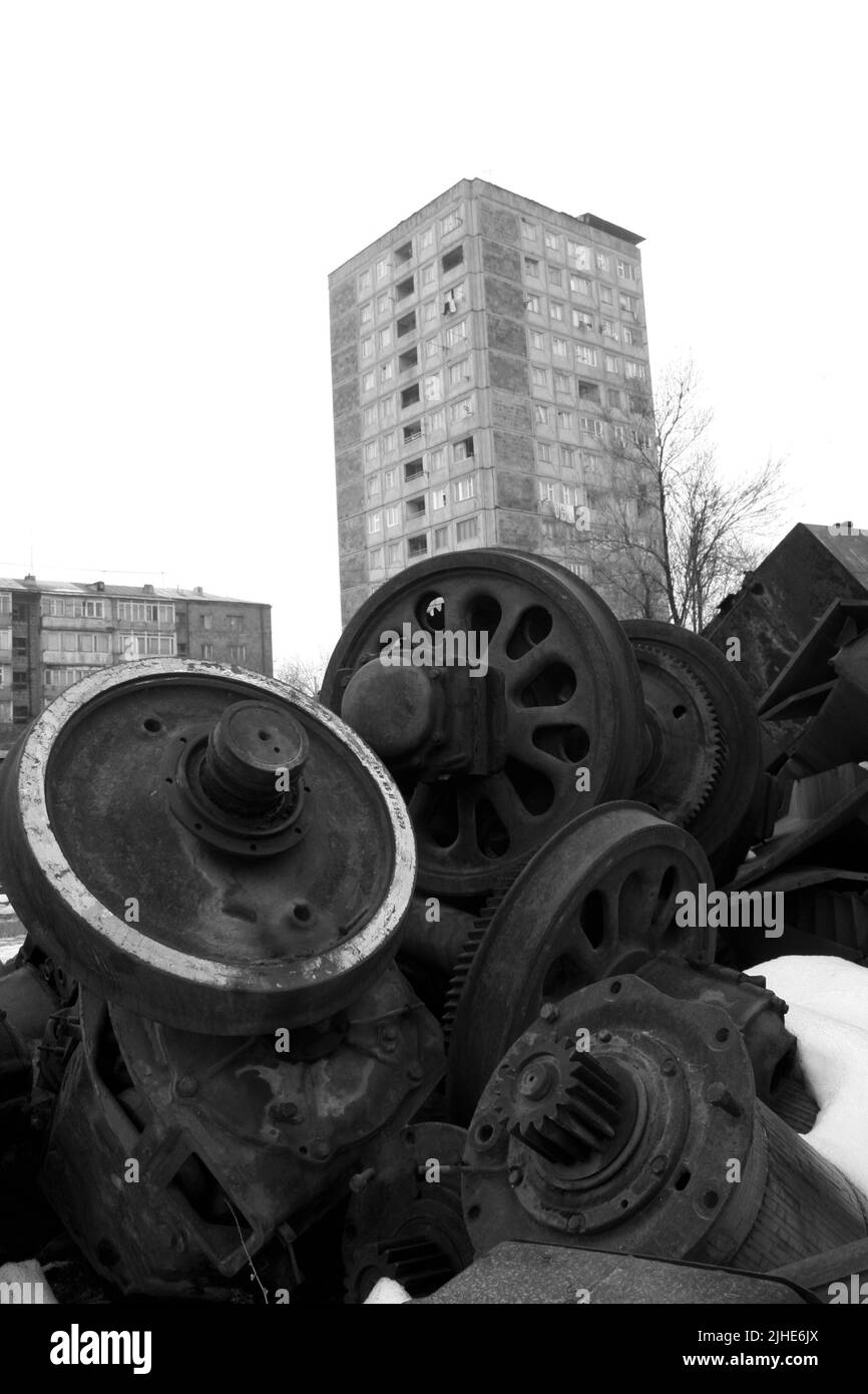 A vertical grayscale close-up of train waste with building on the ...