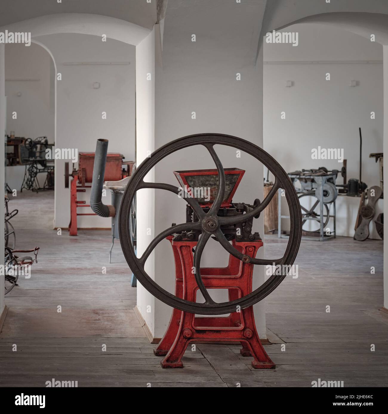Old retro metal red machine with big wheel inside in room Stock Photo ...