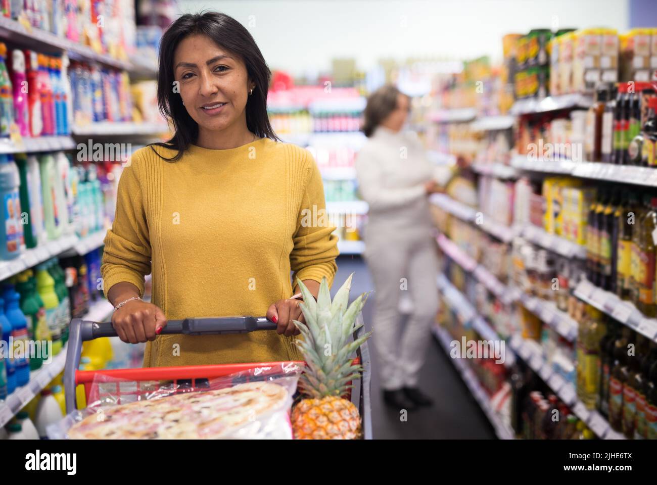 Woman shopping at store, walking among shelves Stock Photo - Alamy