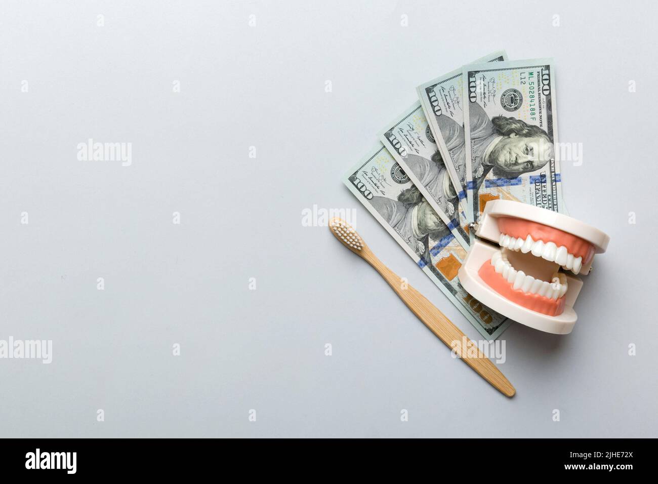 Closeup model of a human jaw with white teeth and dollar bill ...