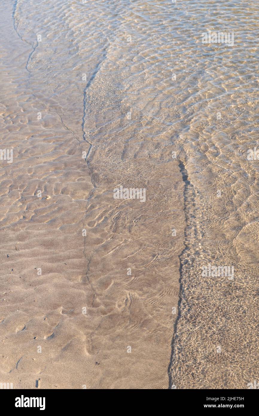 Detail close-up of wave washing onto sand beach shoreline Stock Photo ...