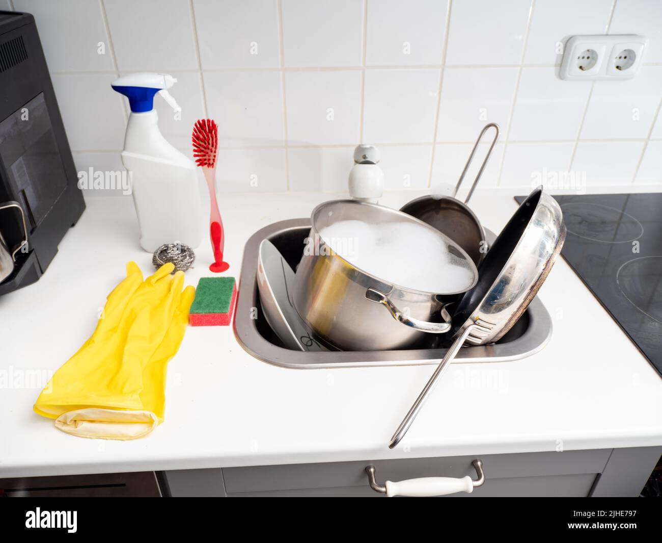 Washing dishes while cleaning the house. Kitchen cleaning. Dirty dishes ...