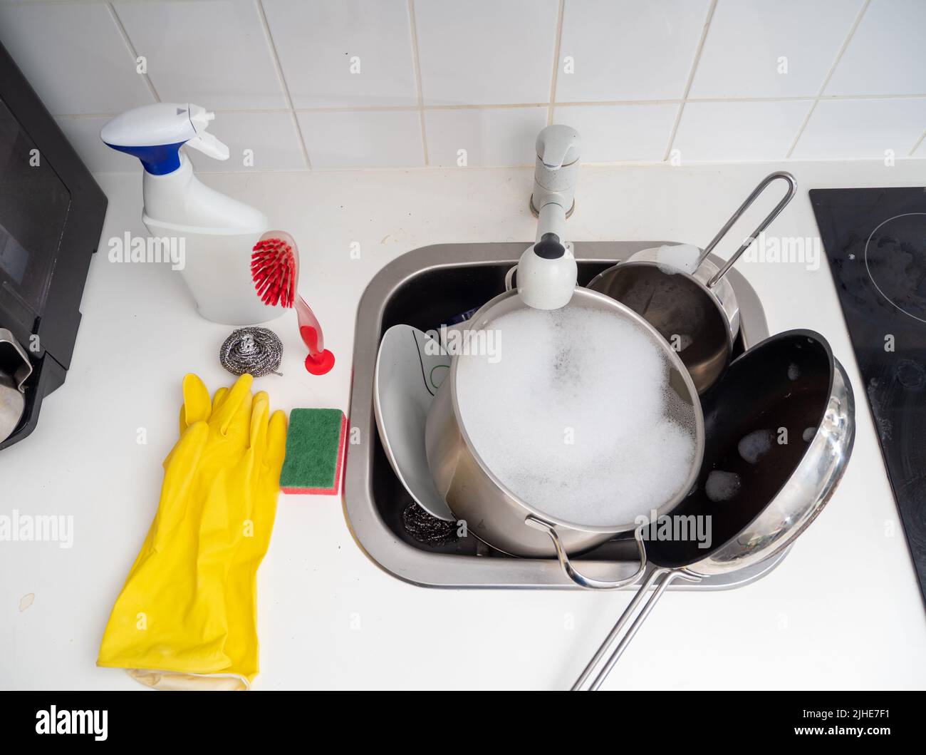 Washing dishes while cleaning the house. Kitchen cleaning. Dirty dishes ...
