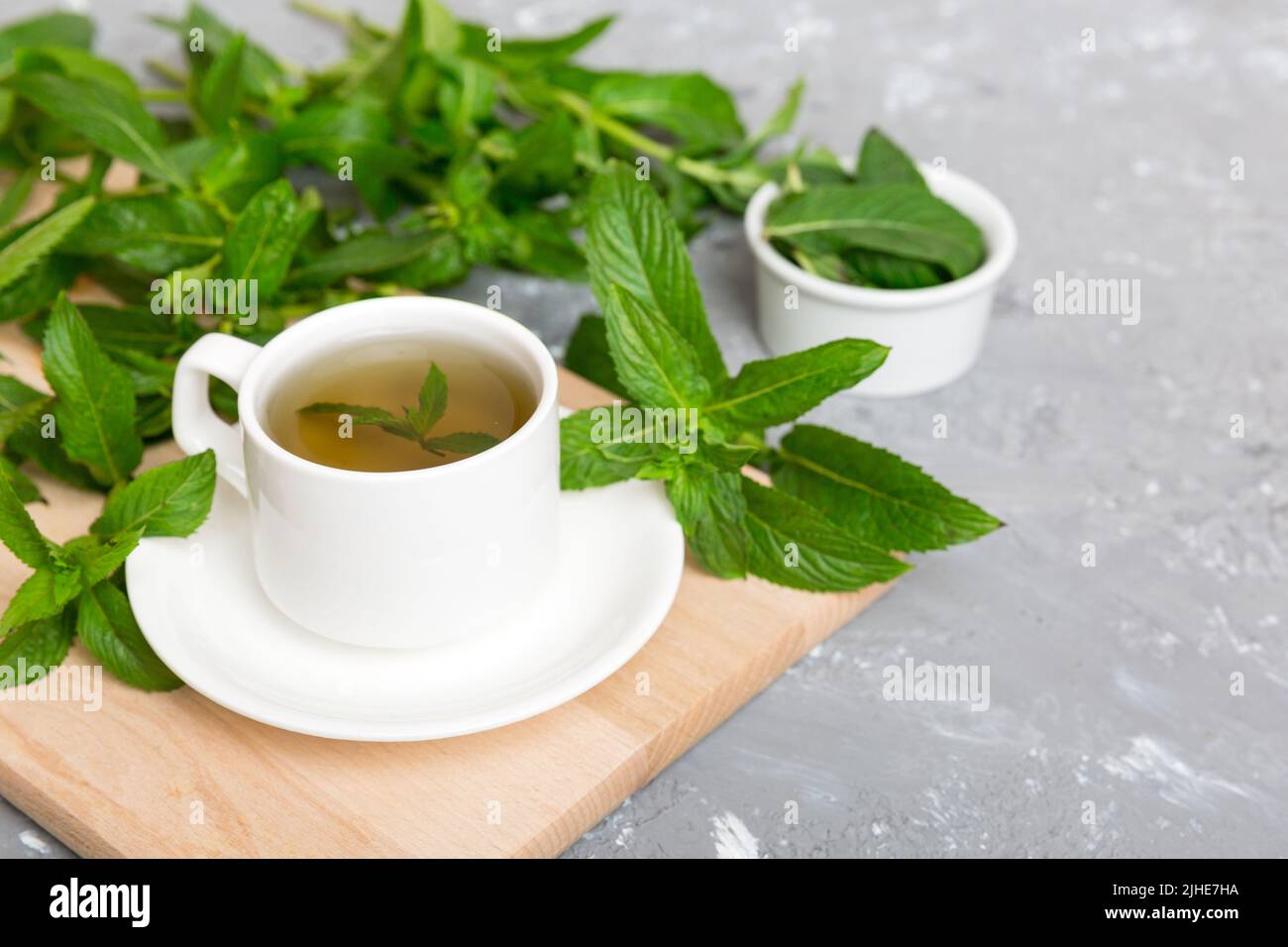 Cup of mint tea on table background. Green tea with fresh mint top view ...