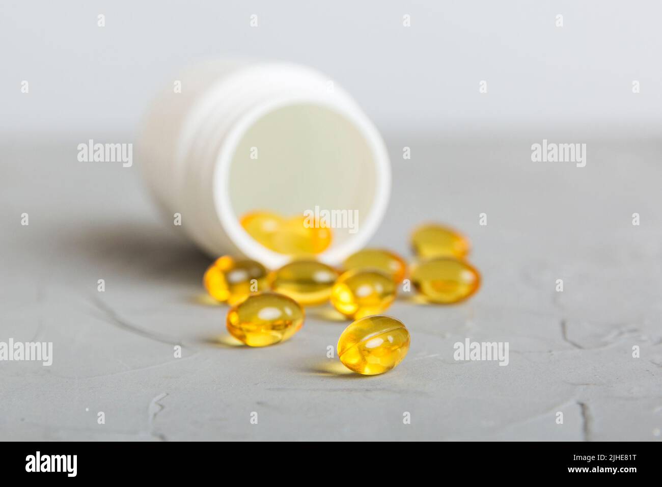 Soft gels pills with Omega-3 oil spilling out of pill bottle close-up ...