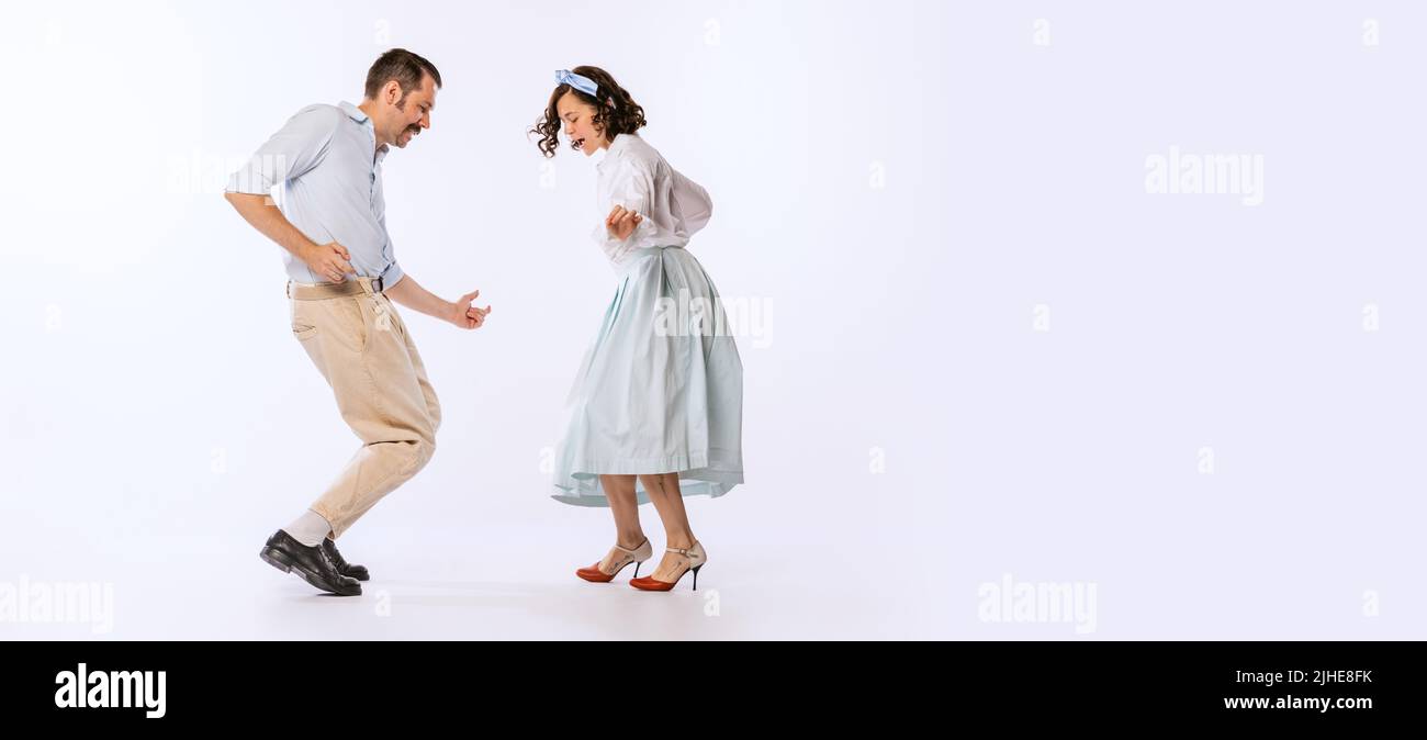 Portrait of young beautiful couple, man and woman, dancing retro dance ...