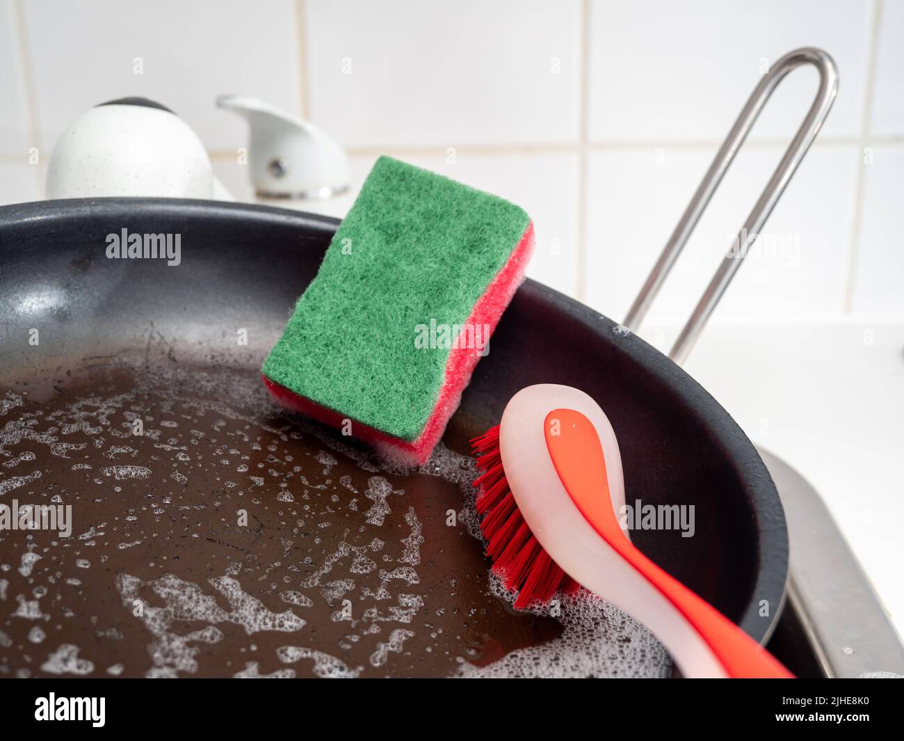 Washing dishes while cleaning the house. Kitchen cleaning. Dirty dishes ...