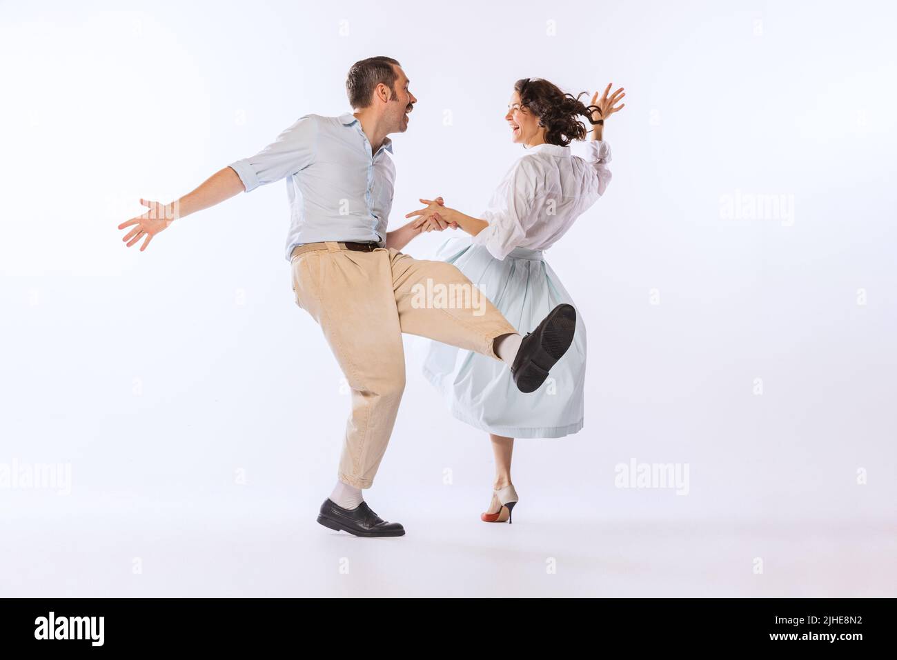 Portrait of young stylish couple, man and woman, dancing isolated over ...