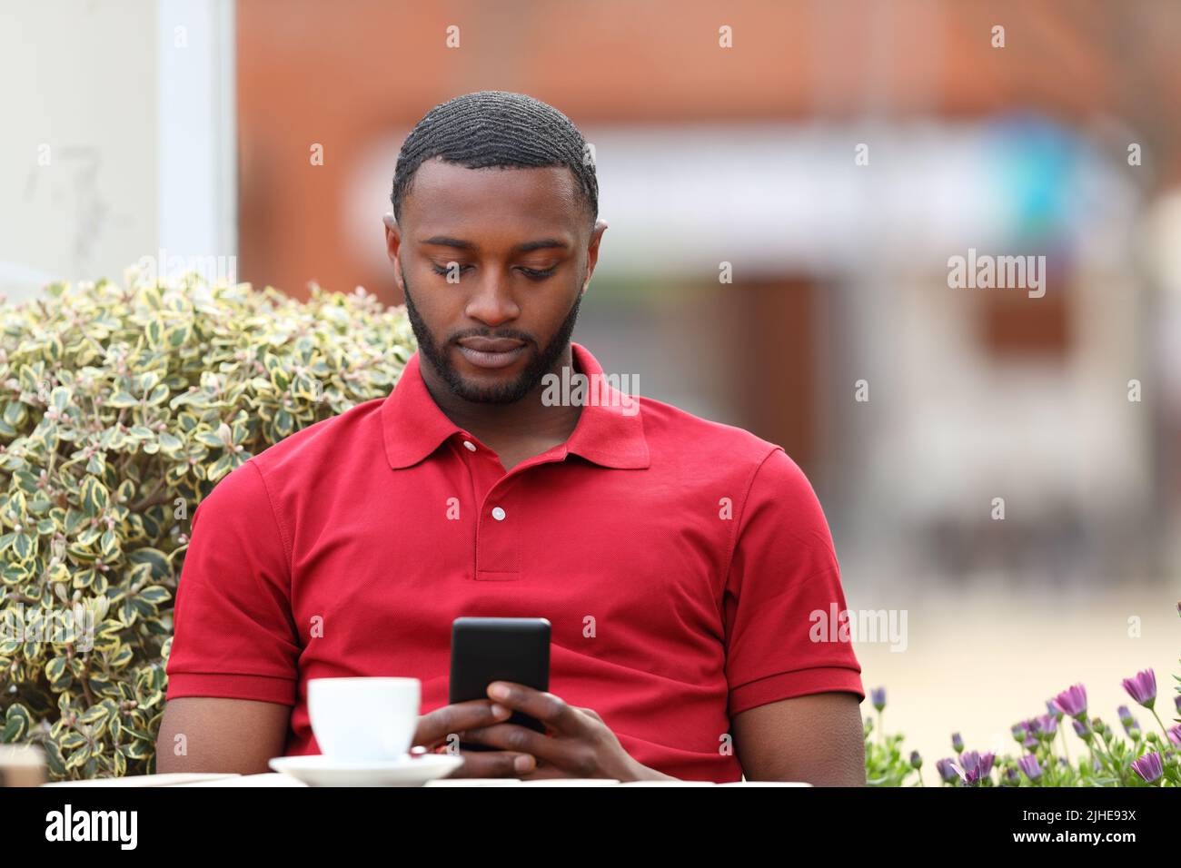 Front view portrait of a serious black man using phone in a bar Stock ...