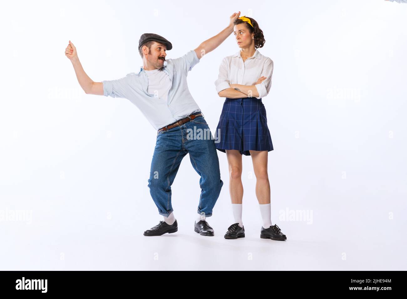 Portrait of young stylish woman looking at dancing cheerful man ...