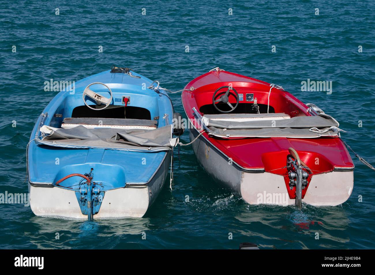 Old two boats, red and blue boats on lake. Clean water Stock Photo - Alamy