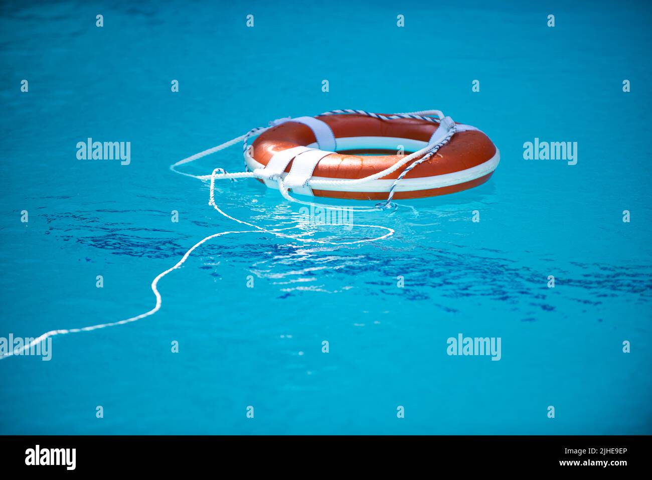 Life buoy in blue swimming pool. Lifebuoy pool ring float on blue water ...