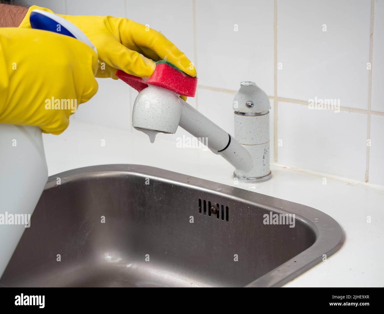 Cleans the kitchen faucet. Kitchen cleaning. Dirty electric stove Stock ...