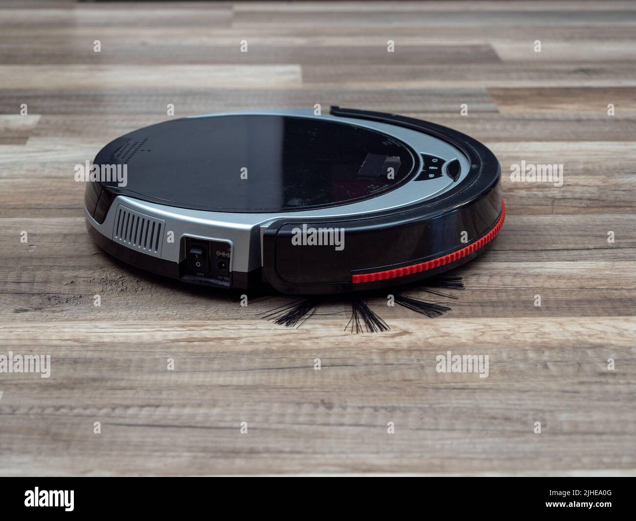 Robotic vacuum cleaner on a laminated wooden floor. Robot vacuum ...