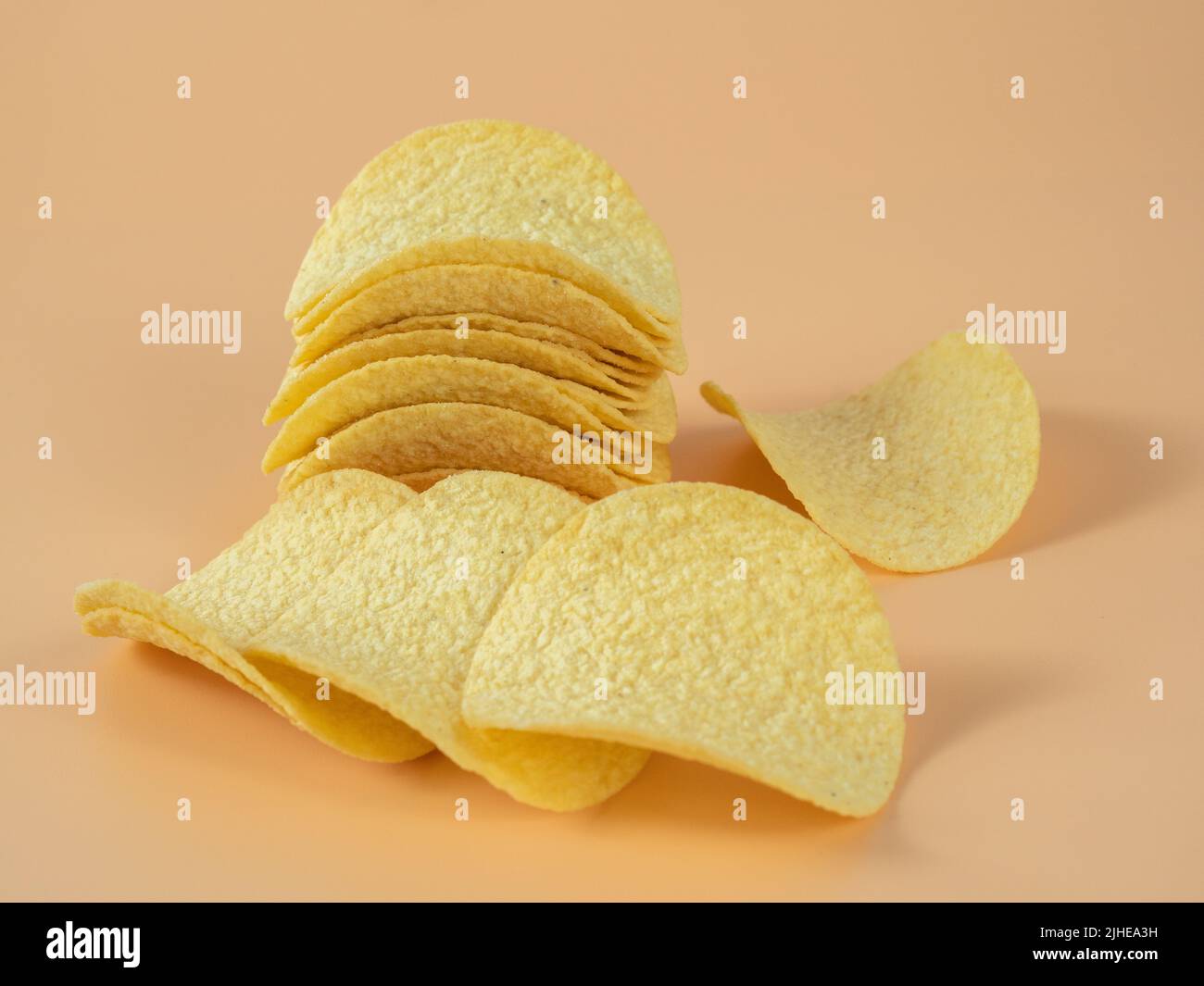 Crisps. Crispy potatoes. Potato chips on an orange background. Close-up ...