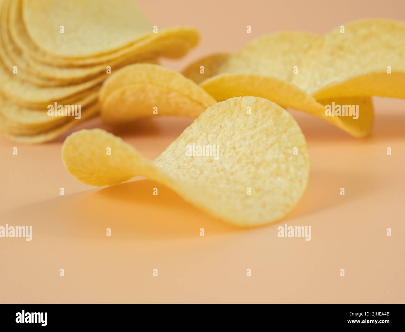 Crisps. Crispy potatoes. Potato chips on an orange background. Close-up ...