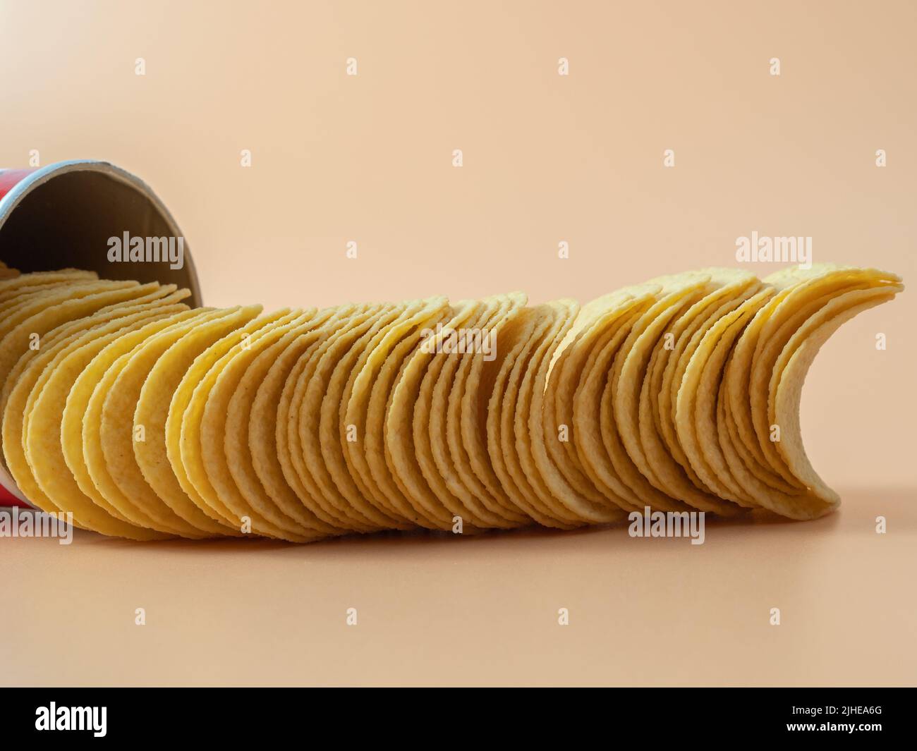 Crisps. Crispy potatoes. Potato chips on an orange background. Close-up ...