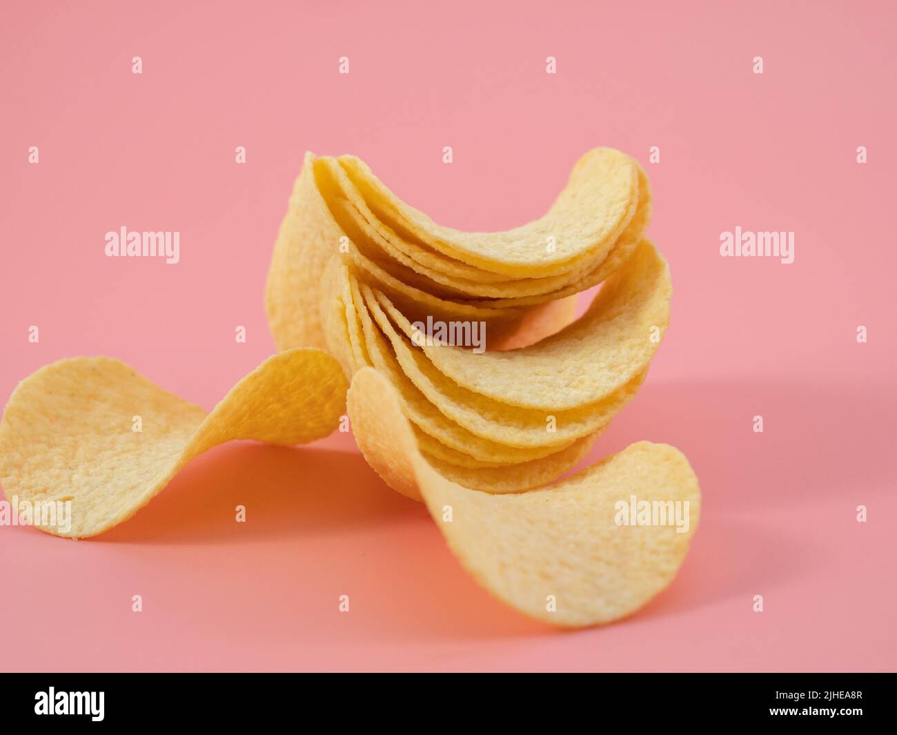 Crisps. Crispy potatoes. Potato chips on a pink background. Close-up ...
