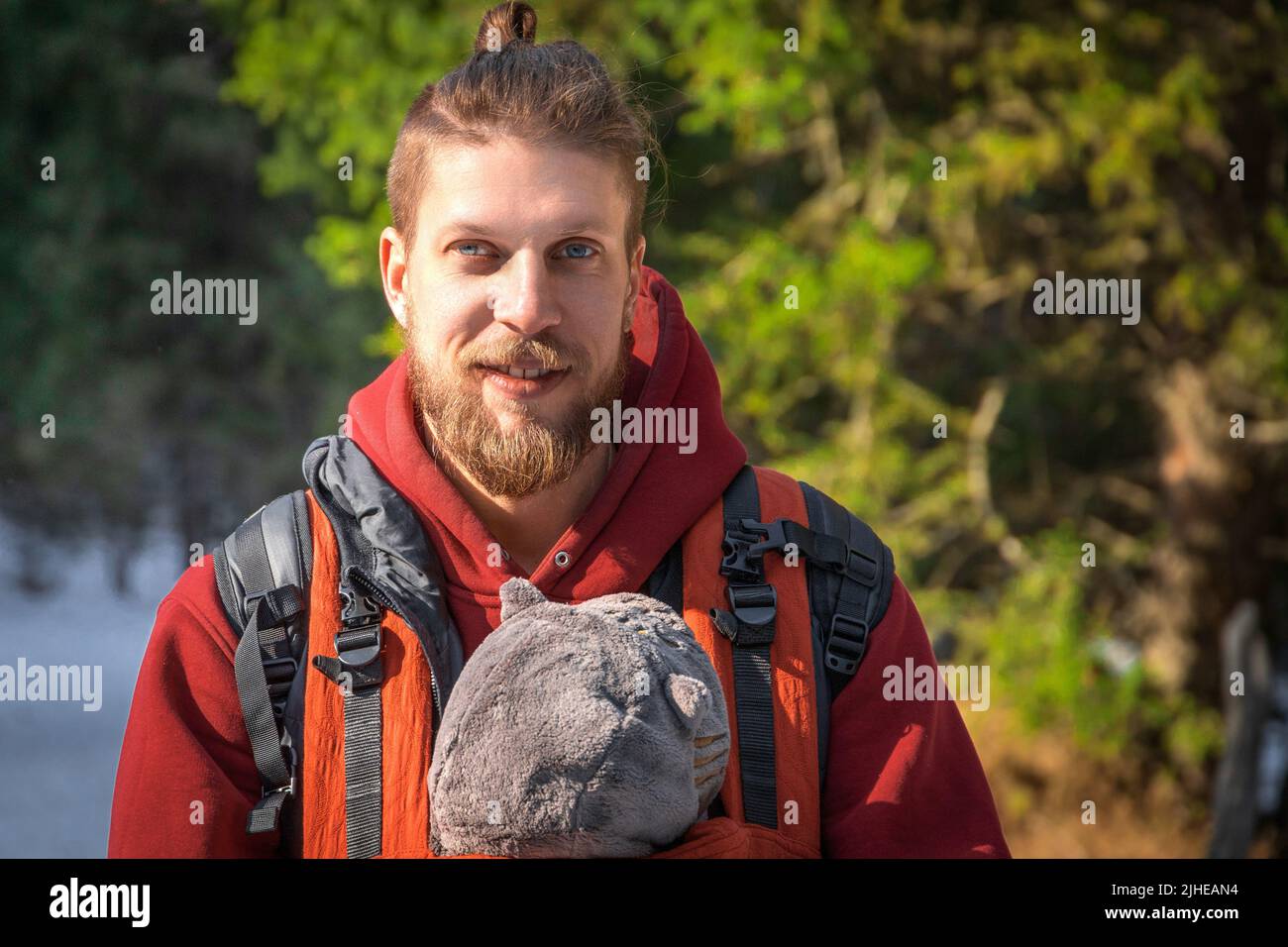 Portrait of bearded babywearing father with his son in baby carrier ...