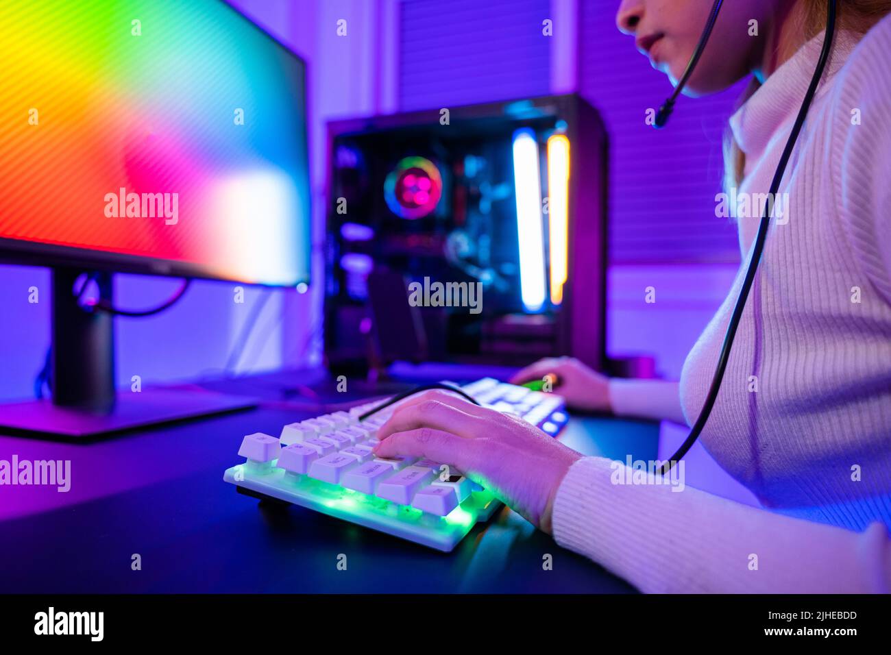 Close up gamer hands actively pushing buttons with colorful neon LED ...